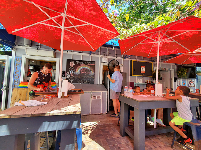 Red umbrellas provide shade while diners engage in the sacred ritual of contemplating whether to order seconds or save room for key lime pie.