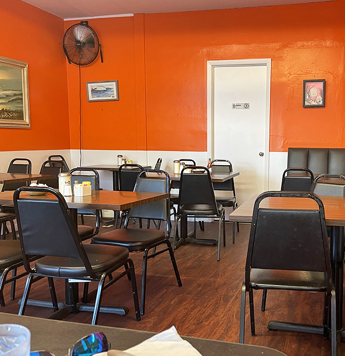 Simple tables, practical chairs, and the promise of food that makes fancy d&eacute;cor unnecessary. The orange walls say all you need to know.
