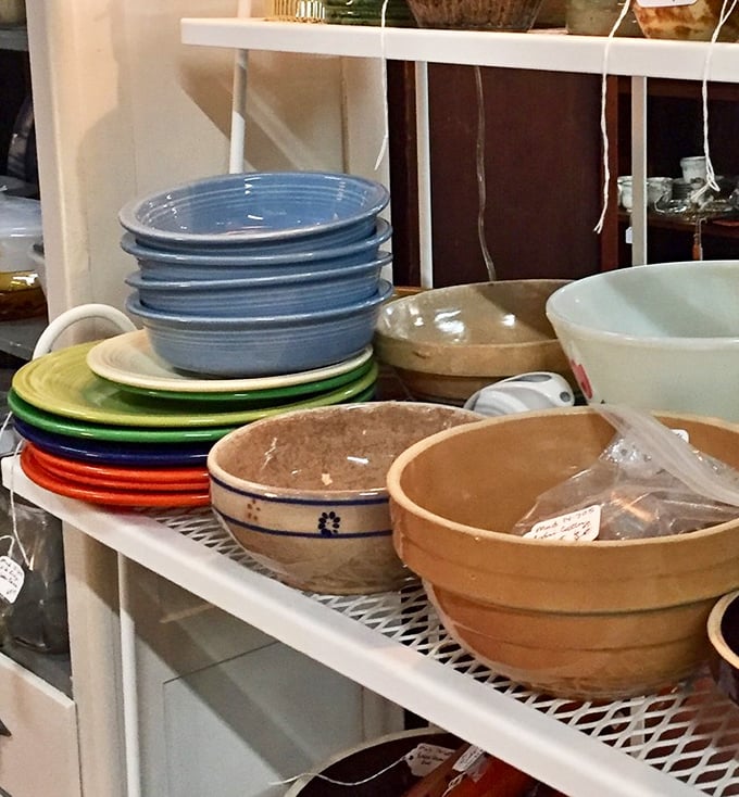 Fiestaware in rainbow hues shares shelf space with rustic crockery, proving that dinner parties were Instagram-worthy long before social media existed. 