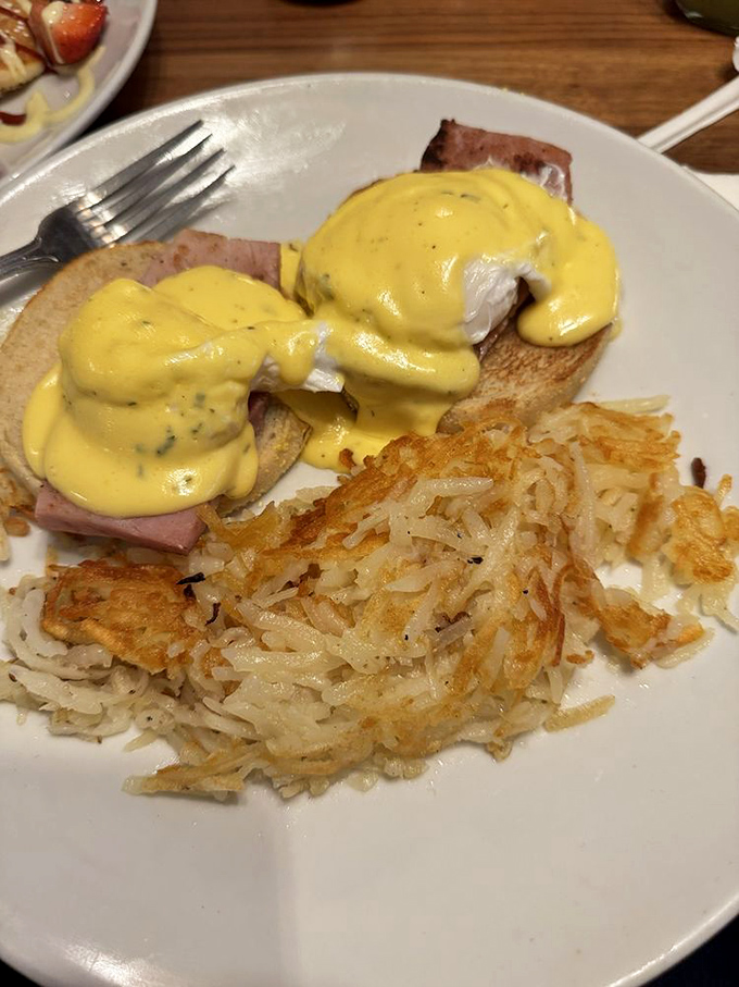 Eggs Benedict with hollandaise so yellow it could guide traffic. Those hash browns are the crispy supporting actors who steal the show.