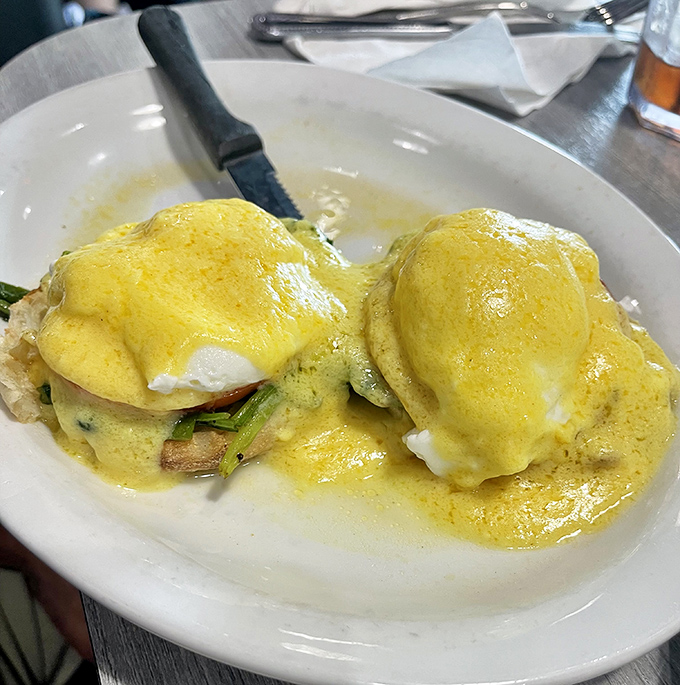 Eggs Benedict executed with textbook perfection. That hollandaise sauce looks so velvety it could double as a silk pillow for those poached eggs.