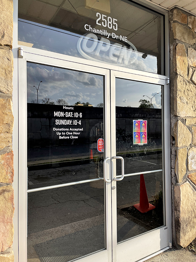 The entrance reveals the store's practical details. Those hours (10-6 weekdays, 10-4 Sundays) are your window to thrifting paradise.