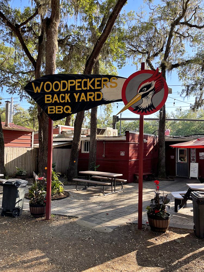 The entrance sign stands like a BBQ beacon among the Spanish moss. That woodpecker isn't just a logo&mdash;it's a promise of good things to come.