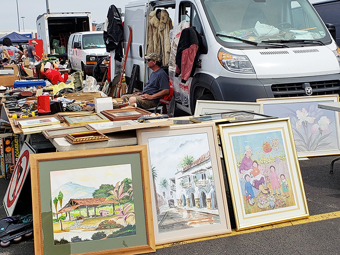 Framed artwork leans casually against a vendor's van&mdash;someone's discarded watercolor might become your living room's conversation piece for decades to come.