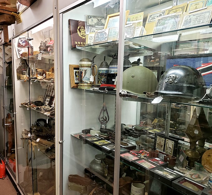 Military helmets and field gear stand at attention behind glass, silent witnesses to history's most consequential chapters.