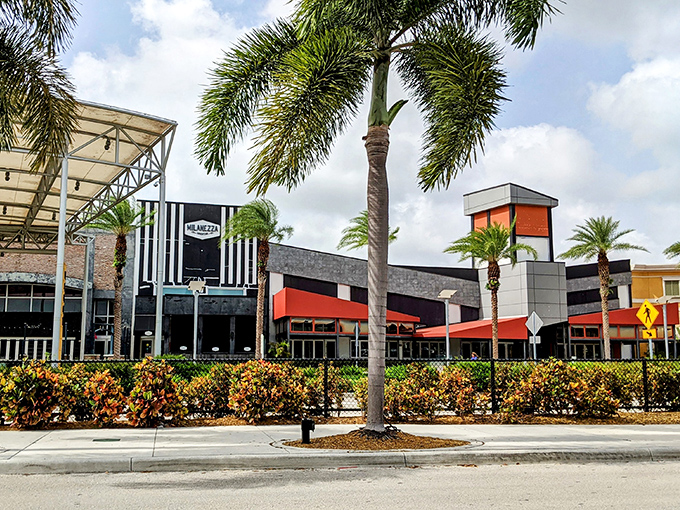 Modern storefronts with bold red awnings create a striking contrast against Miami's blue skies. Even from outside, the mall promises retail adventures within.