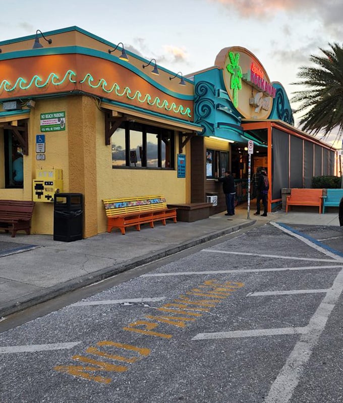 As the sun sets on Clearwater Beach, Frenchy's neon sign glows like a beacon for hungry souls seeking seafood salvation.