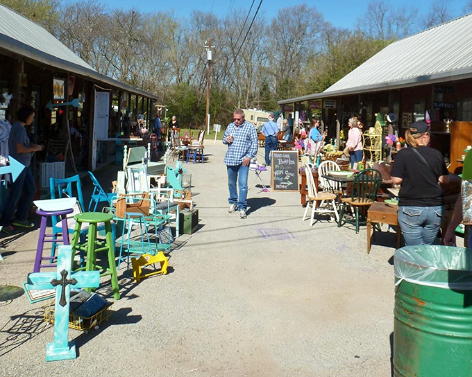 Painted furniture and repurposed treasures line this outdoor walkway. That turquoise cross would look perfect in your entryway&mdash;admit it.