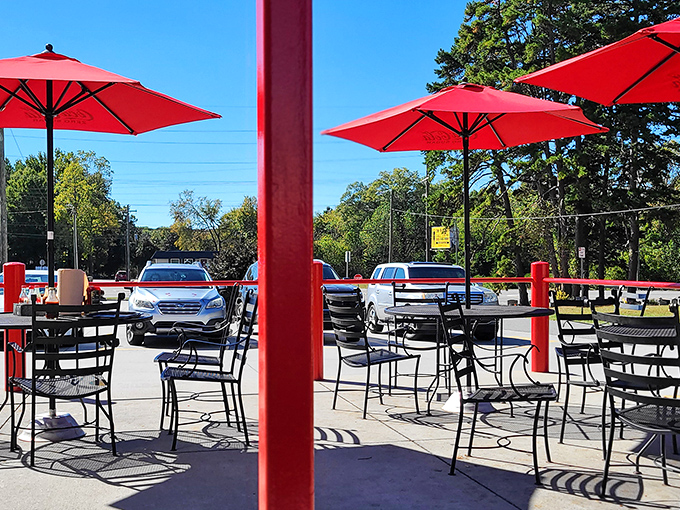 Al fresco dining with a side of sunshine. Those red umbrellas aren't just for shade &ndash; they're beacons calling hungry travelers home.