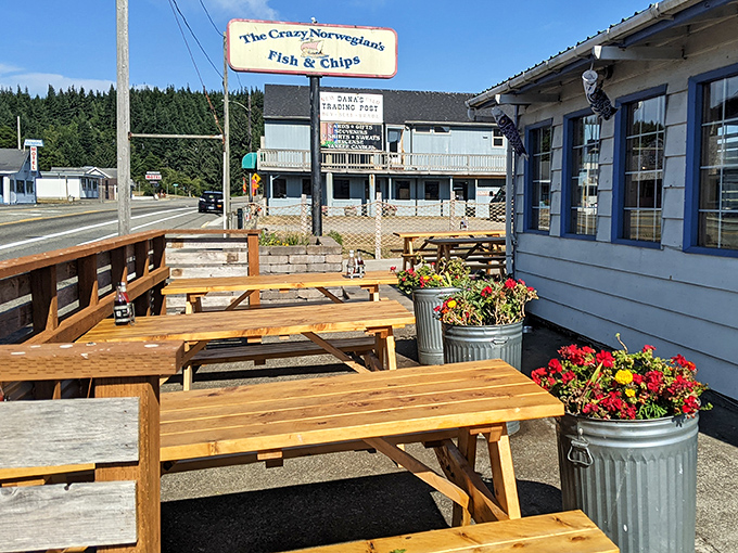 Outdoor picnic tables bathed in Oregon sunshine, with flower-filled planters standing guard. The perfect spot for post-fish-and-chips contemplation.