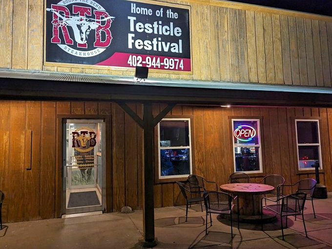 Evening brings a warm glow to the wooden exterior, with simple outdoor seating for enjoying Nebraska's pleasant evenings.