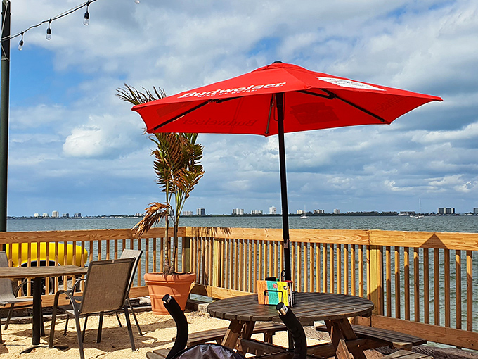Outdoor seating with water views and a Budweiser umbrella—because sometimes paradise comes with brand sponsorship and a gentle breeze.