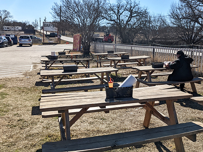 Rustic outdoor seating where the Texas breeze carries hints of post oak smoke. Even the picnic tables look excited about what's coming.