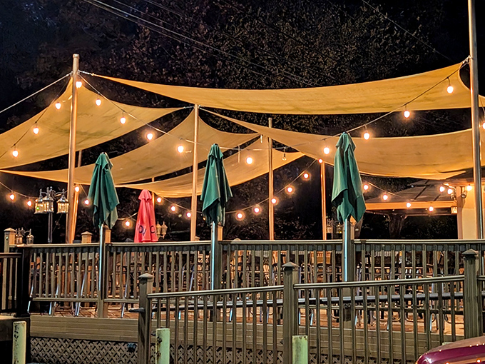 As evening falls, the outdoor deck transforms into a magical space where food, drinks, and conversation flow under twinkling lights.