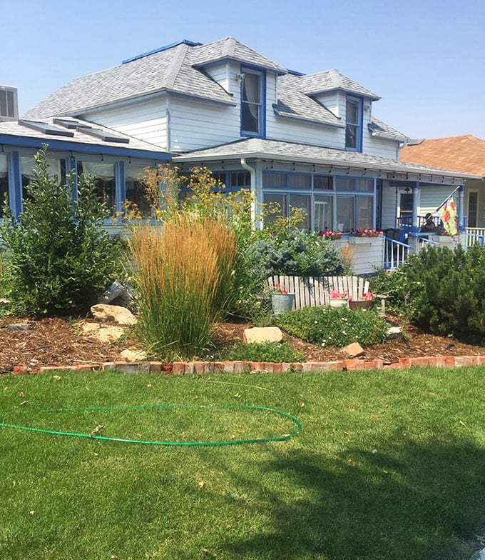 Summer reveals the Cottage Cafe's other personality: a garden oasis where ornamental grasses and thoughtful landscaping frame the charming blue-trimmed building.