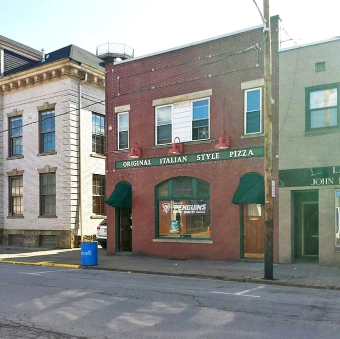 Nestled between neighboring buildings, this unassuming brick structure houses pizza dreams that have satisfied Ambridge appetites for generations.