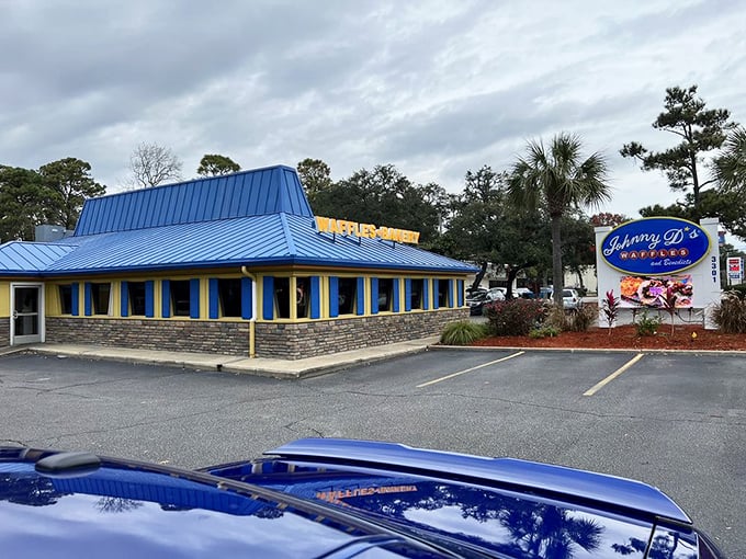 The bright blue roof serves as a breakfast lighthouse, guiding hungry souls through Myrtle Beach morning traffic toward waffle salvation.