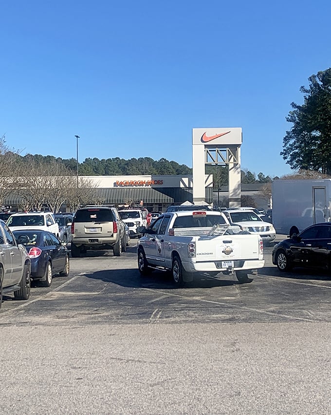 The Nike swoosh towers above the parking lot like a monument to athletic aspirations and wallet-friendly workout gear.