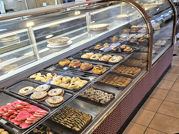 That bakery case is basically a dessert museum where everything's for sale and nothing requires a doctorate to enjoy.