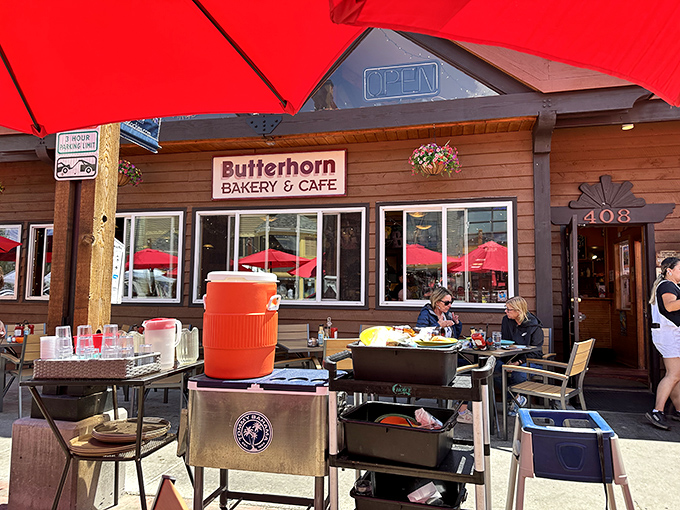 Outdoor seating under red umbrellas&mdash;because mountain views and pancakes are nature's perfect pairing, like sunshine and happiness.
