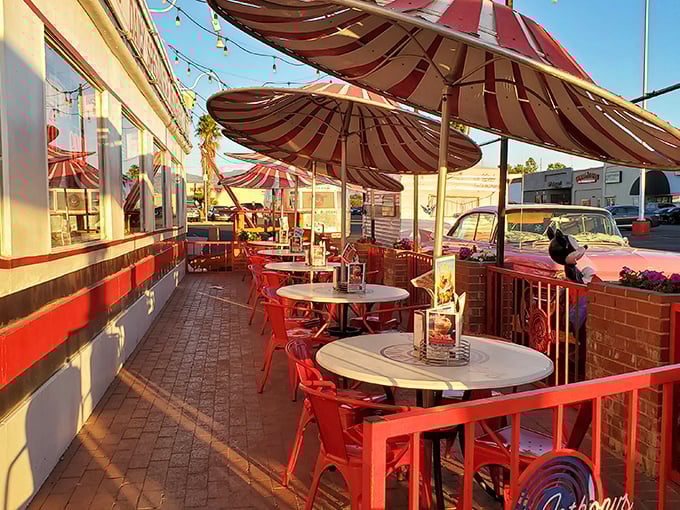 The outdoor patio offers desert dining under cheerful umbrellas, where classic cars occasionally roll up like celebrities making an entrance.