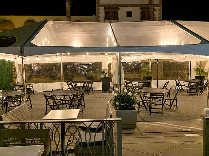 The outdoor patio, strung with twinkling lights, offers a magical setting for evening dining. Clear panels protect from coastal breezes while maintaining the connection to Ventura's charming streets.