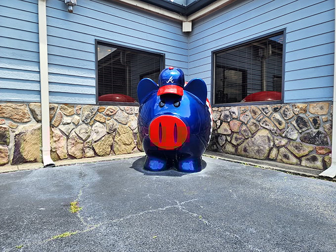 This blue pig statue stands guard outside like a porcine sentinel, his expression suggesting he knows exactly how good the barbecue inside really is.