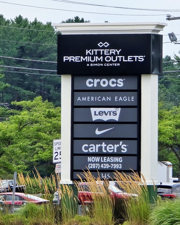 The roadside sign stands like a retail roll call of America's favorite brands, promising fashion democracy for all who enter.