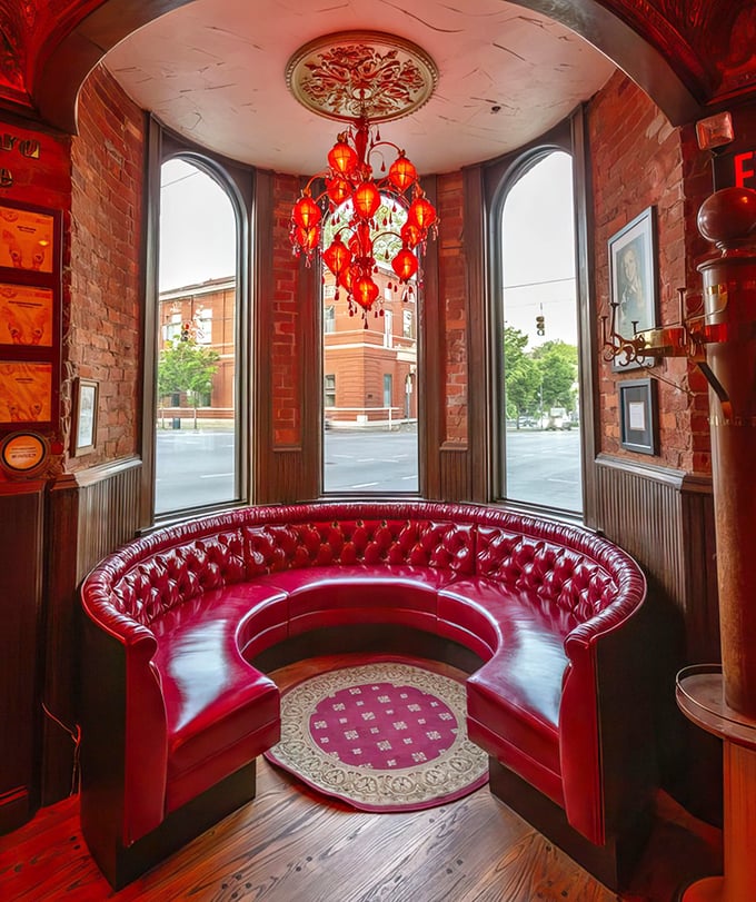The crimson booth where conversations flow as smoothly as fine wine, beneath a chandelier that's witnessed countless toasts.
