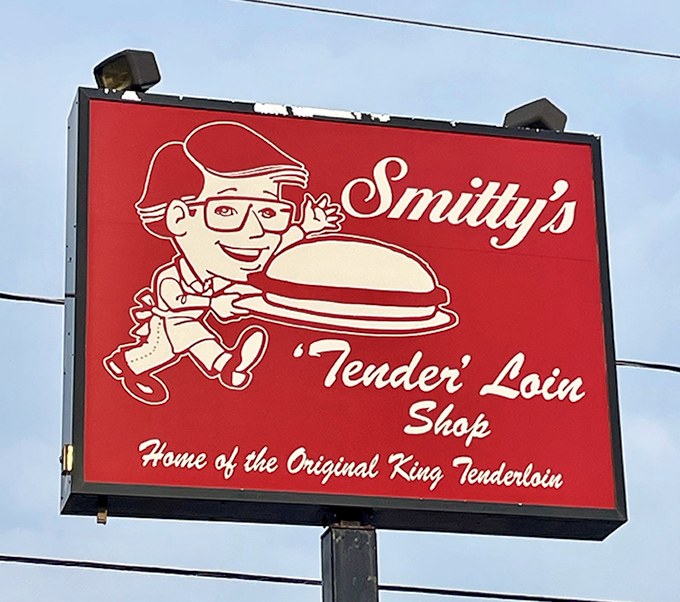 The sign says it all—a cartoon character proudly holding what looks like a UFO but is actually Iowa's favorite sandwich. Truth in advertising at its finest.