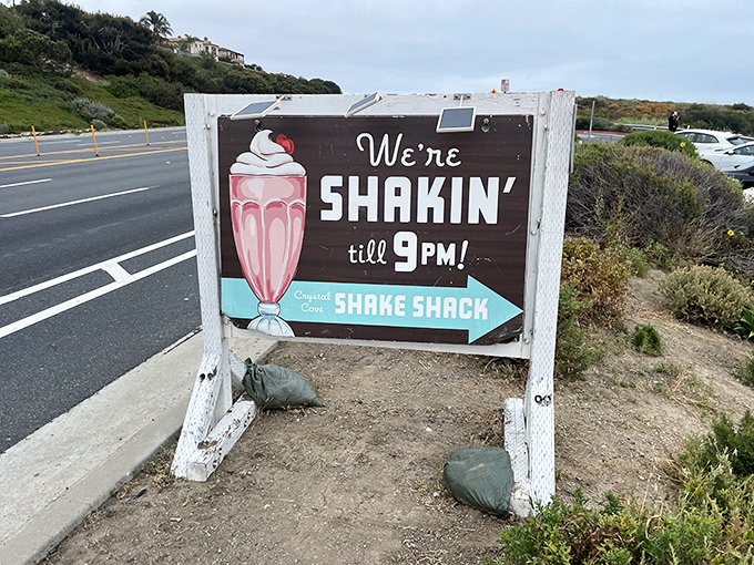 "We're Shakin' till 9PM!"&mdash;a roadside sign that promises milkshake happiness well into the evening hours. The pink shake illustration seals the deal.