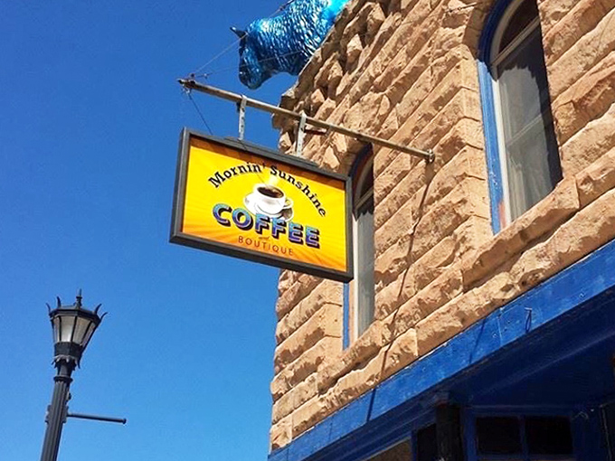 The sunny yellow sign swinging against historic sandstone is the Black Hills equivalent of a lighthouse, guiding hungry travelers to safe harbor.