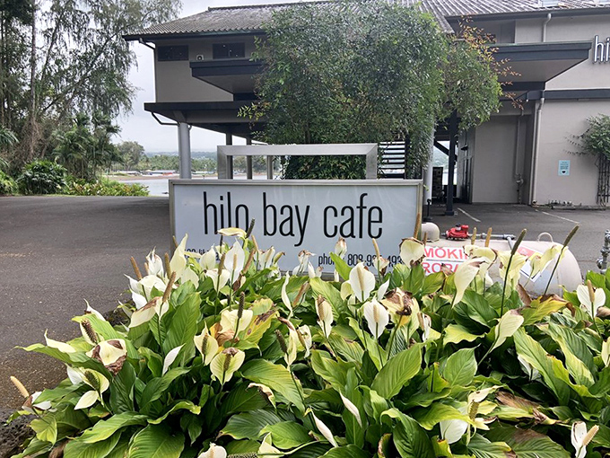 The welcoming sign surrounded by tropical foliage &ndash; your first hint that this isn't just another roadside eatery.