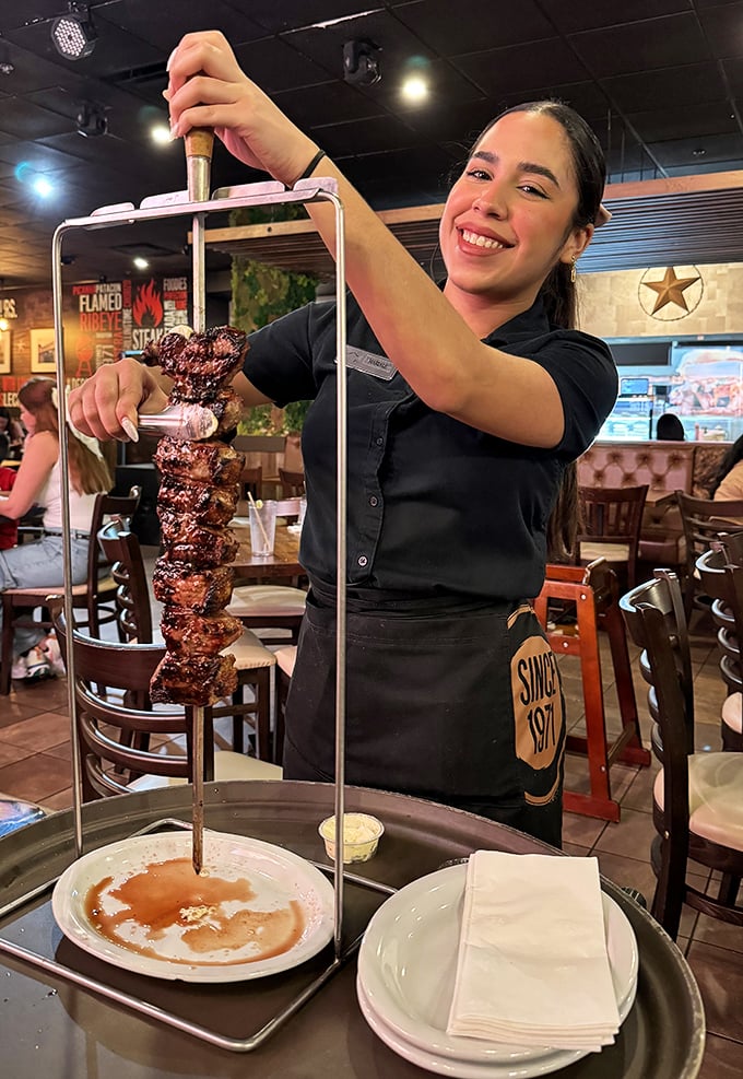 Tableside service elevates the dining experience to performance art. This skewer of perfectly grilled meat deserves its standing ovation.