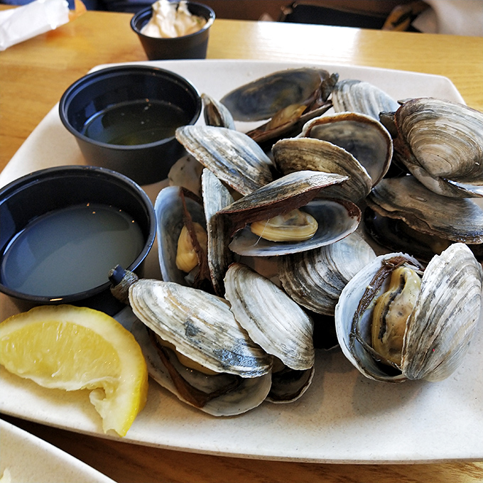 Steamed clams arrive like a treasure chest of bivalves, ready to be dipped in broth that could make a mermaid weep with joy.