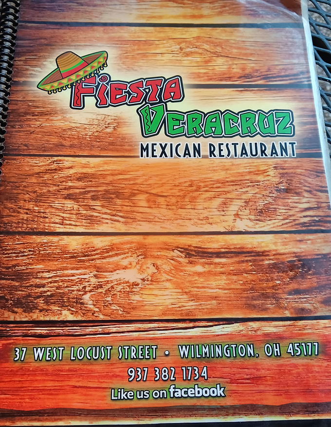 The menu cover tells you everything you need to know: bold flavors, no pretension, and an address worth committing to memory.
