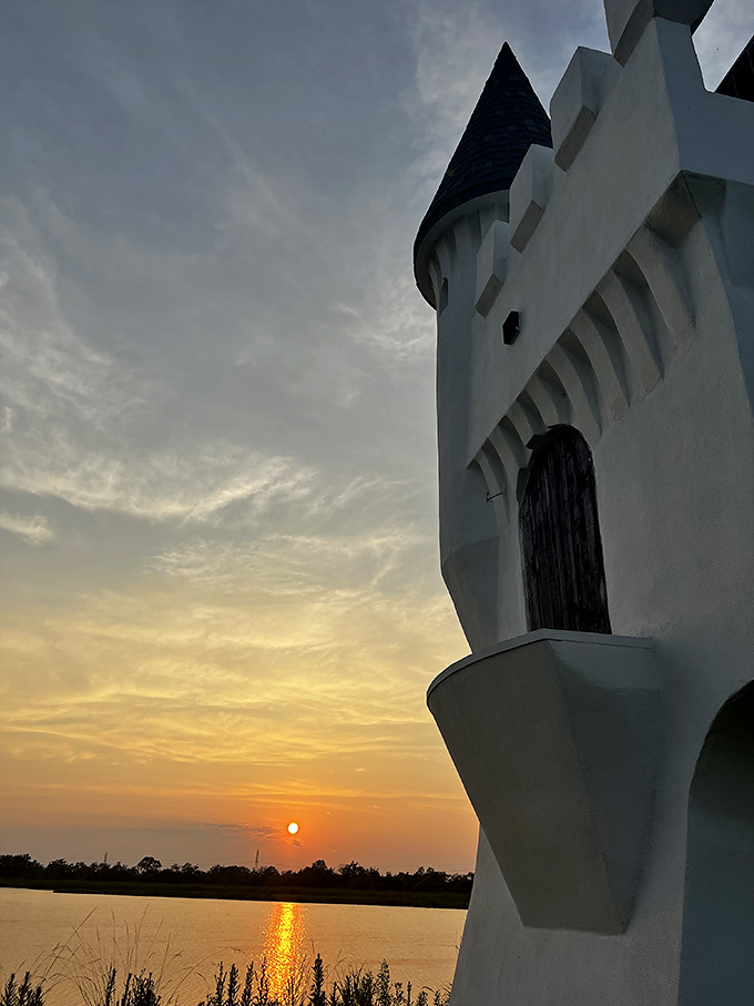 The castle's distinctive profile frames a spectacular sunset, proving that sometimes the best views in Louisiana come with a side of whimsy.