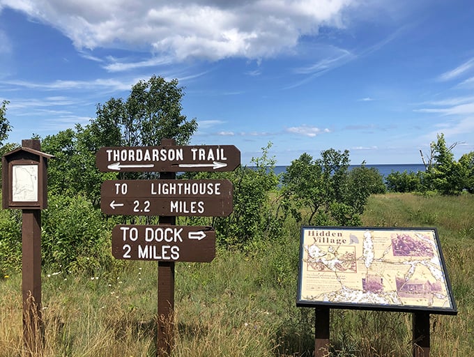 Trail signs pointing to the lighthouse and dock offer distances that seem short on paper but feel epic when carrying camping gear.