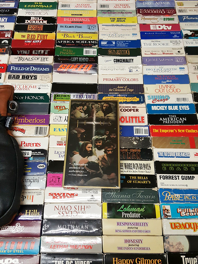 A nostalgic sea of VHS tapes&mdash;where "Forrest Gump" and "Jesus" share shelf space in this analog archive.