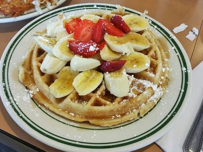 A waffle topped with fresh fruit that makes "eating healthy" feel like cheating. The powdered sugar snowfall is just showing off.