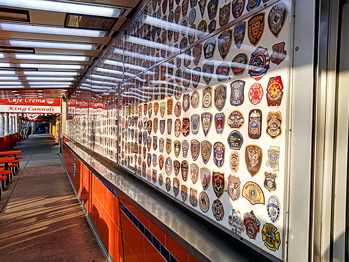 A wall of badges that tells stories of service and community. This collection of police and fire patches shows Geno's deep connection to Philadelphia's heroes.