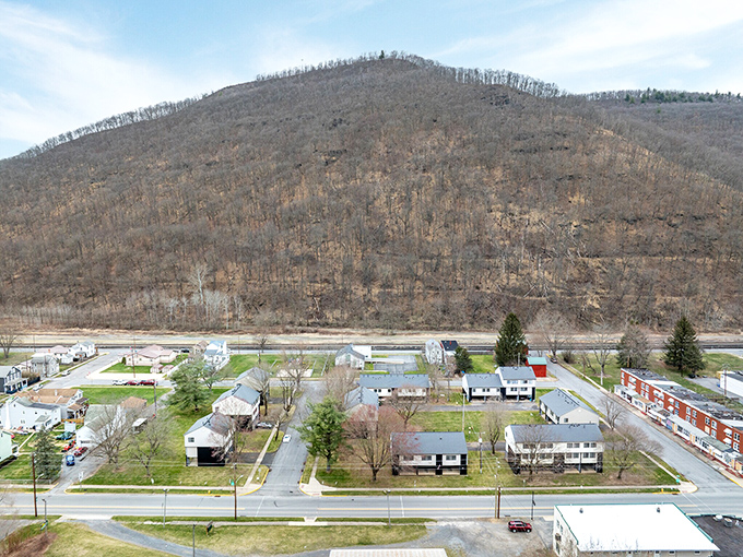 The patchwork of homes below the mountain tells a story of resilience – a community that stands strong through changing seasons and fortunes.
