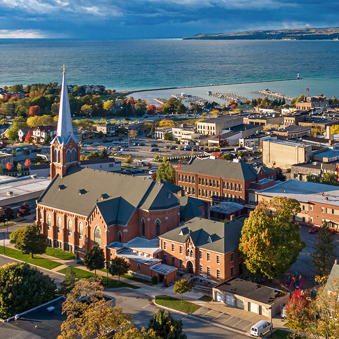 From above, Petoskey reveals its perfect composition – historic architecture, autumn colors, and that endless blue horizon of Lake Michigan.