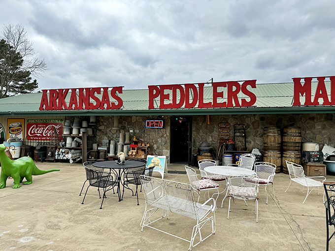 Even on cloudy days, the cheerful red signage of Arkansas Peddlers beckons with promises of treasures waiting just inside.