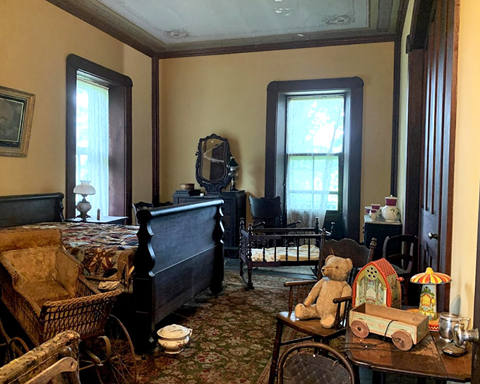 This bedroom's antique toys tell stories of childhoods past. Before screens dominated playtime, wooden wagons and teddy bears ruled the imagination.