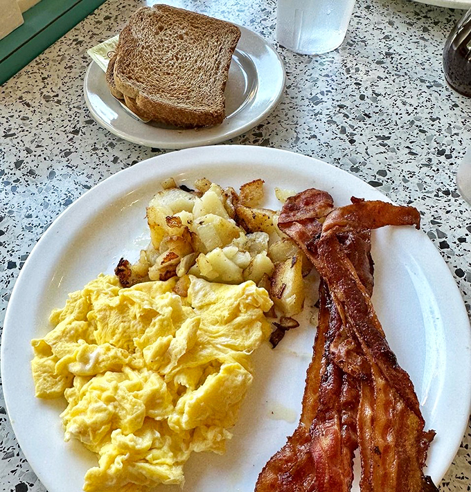Breakfast perfection on a plate&mdash;scrambled eggs with that perfect soft texture, home fries with crispy edges, and bacon that's achieved ideal crispness. Good morning, indeed!