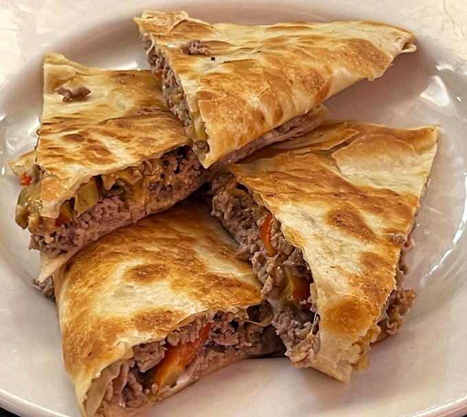 Cheesesteak quesadilla: Philadelphia meets Mexico in a delicious cultural summit. Crispy tortilla triangles reveal the savory treasure hidden within.