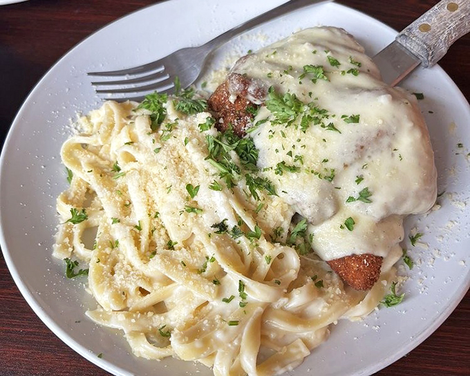 Chicken Romano with fettuccine alfredo&mdash;where golden-fried cutlets and creamy pasta conspire to make you forget about your diet until tomorrow.