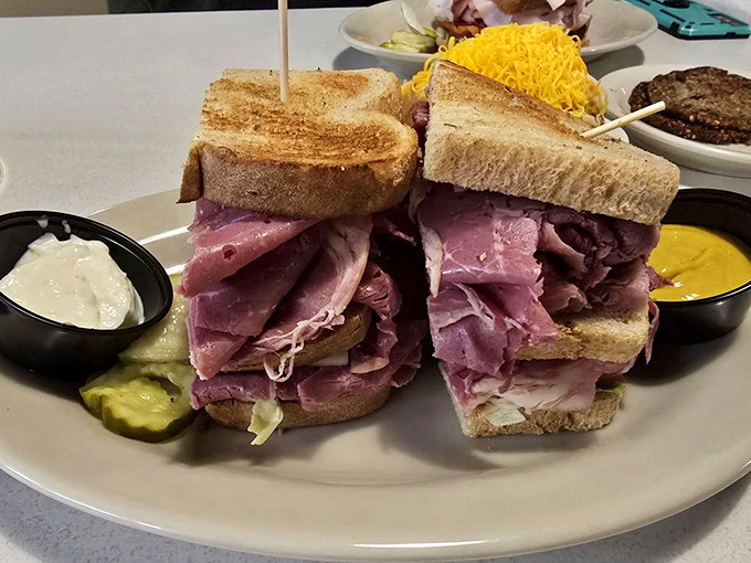 The corned beef sandwich stands tall and proud, like a delicious skyscraper of meat. Those condiment cups are there for the inevitable flavor dipping expedition.