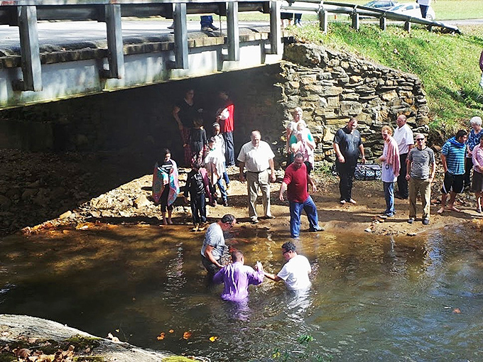 The creek beneath the bridge occasionally serves a higher purpose, hosting community gatherings that connect modern Virginians to traditions as enduring as the bridge itself.